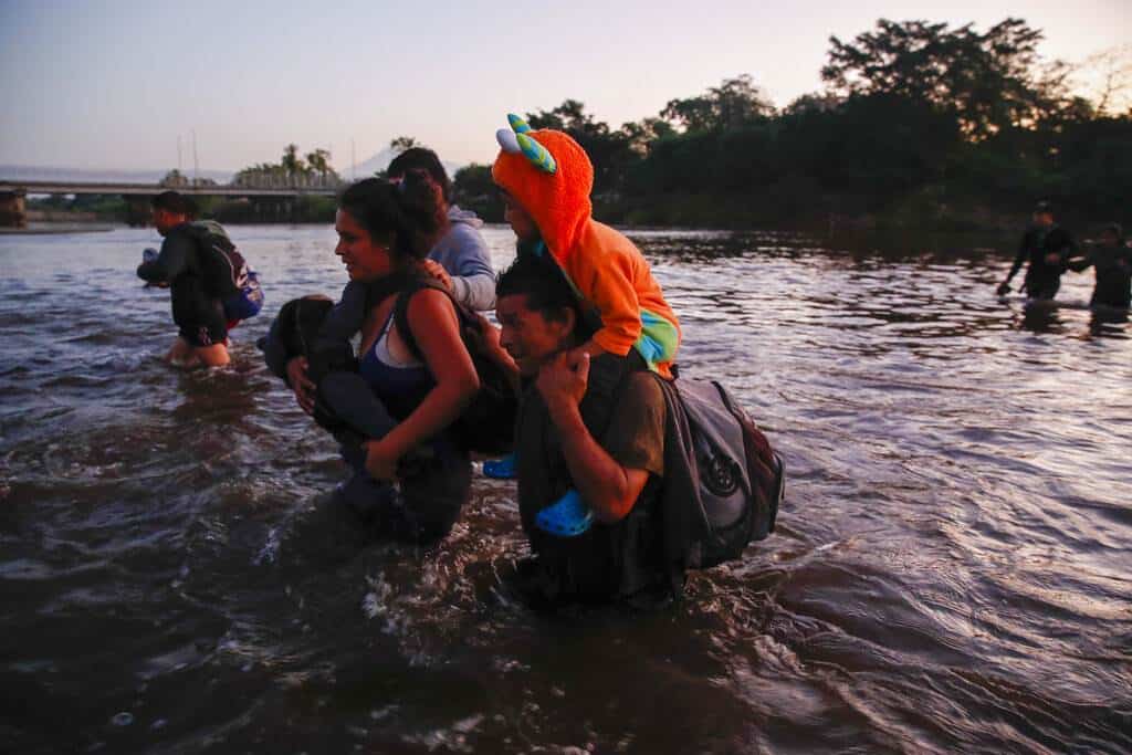 Cientos de migrantes cruzan en grupo el río Suchiate hacia México
