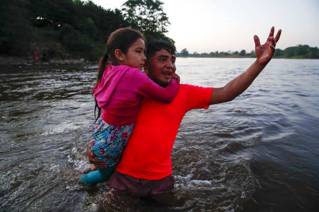 Cientos de migrantes cruzan en grupo el río Suchiate hacia México