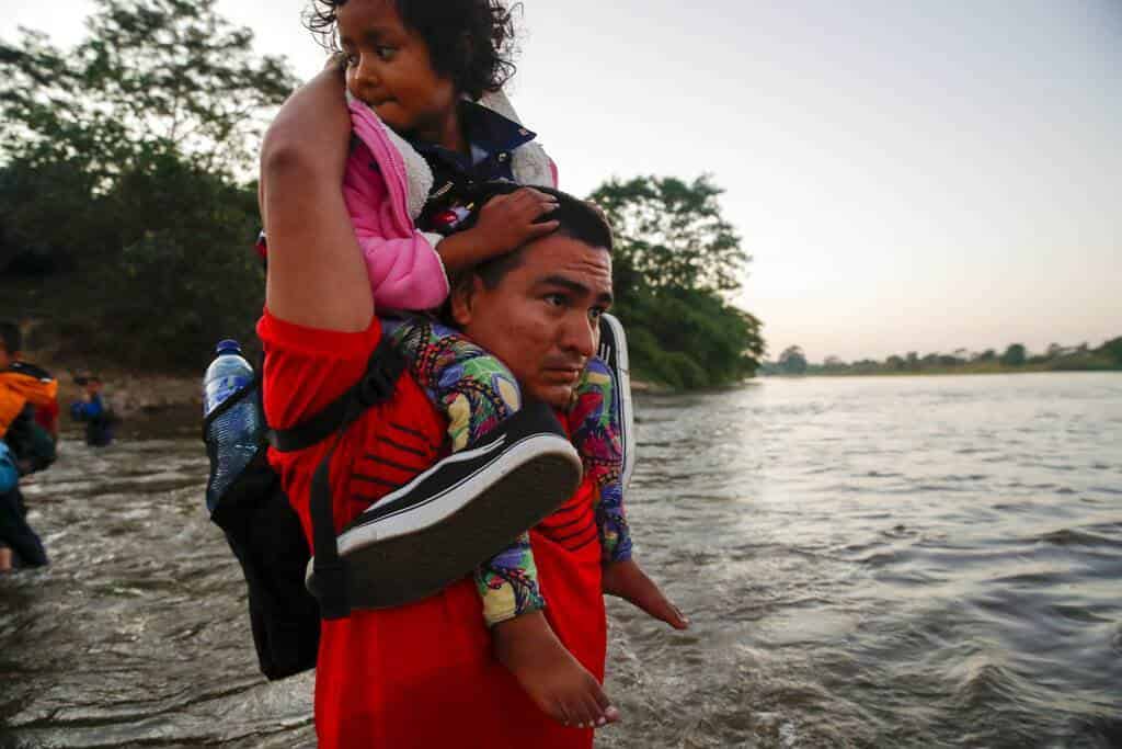 Cientos de migrantes cruzan en grupo el río Suchiate hacia México