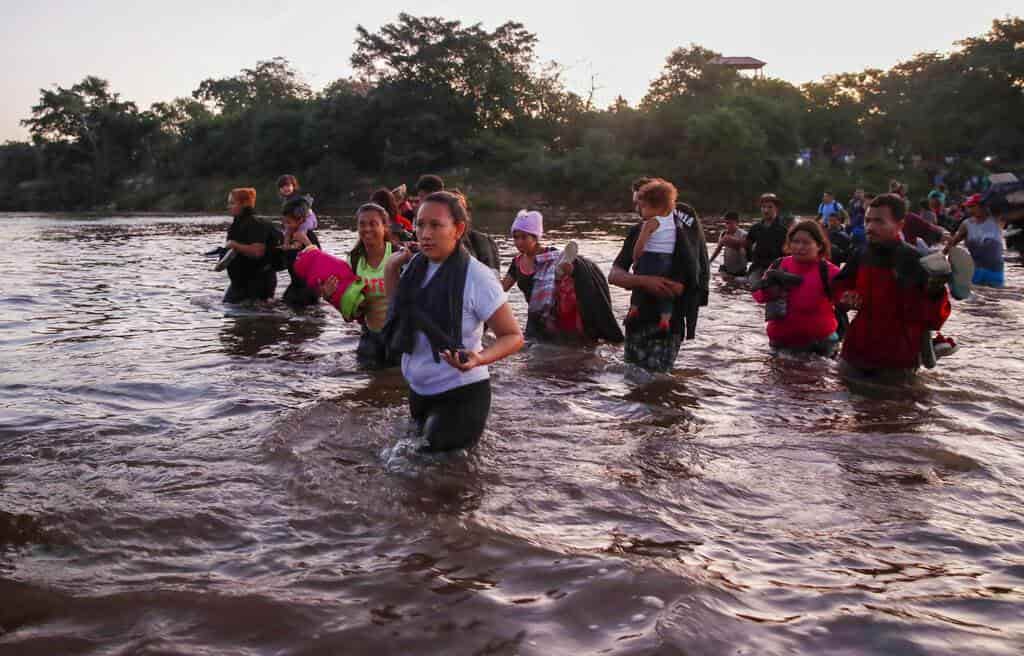 Cientos de migrantes cruzan en grupo el río Suchiate hacia México