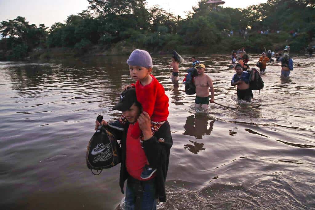 Cientos de migrantes cruzan en grupo el río Suchiate hacia México